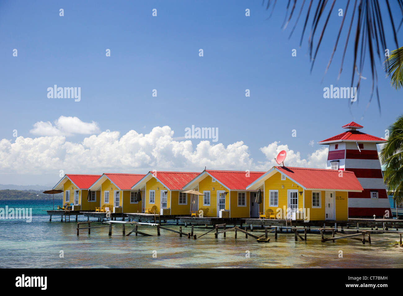 Yellow waterfront cabins at El Faro del Colibri hotel on Isla Carenero ...