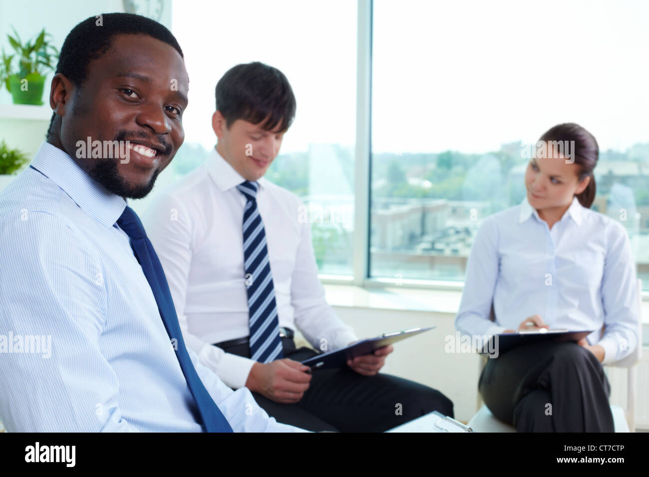 Portrait of successful boss looking at camera in working environment ...