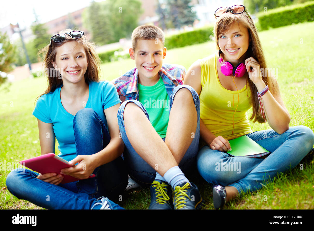 Portrait of three college students enjoying their free time outdoors ...