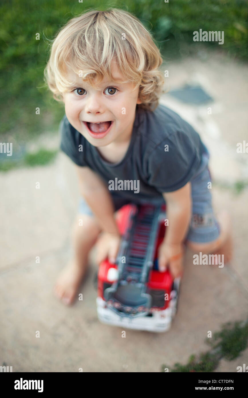 Boy playing with toy fire engine Stock Photo - Alamy