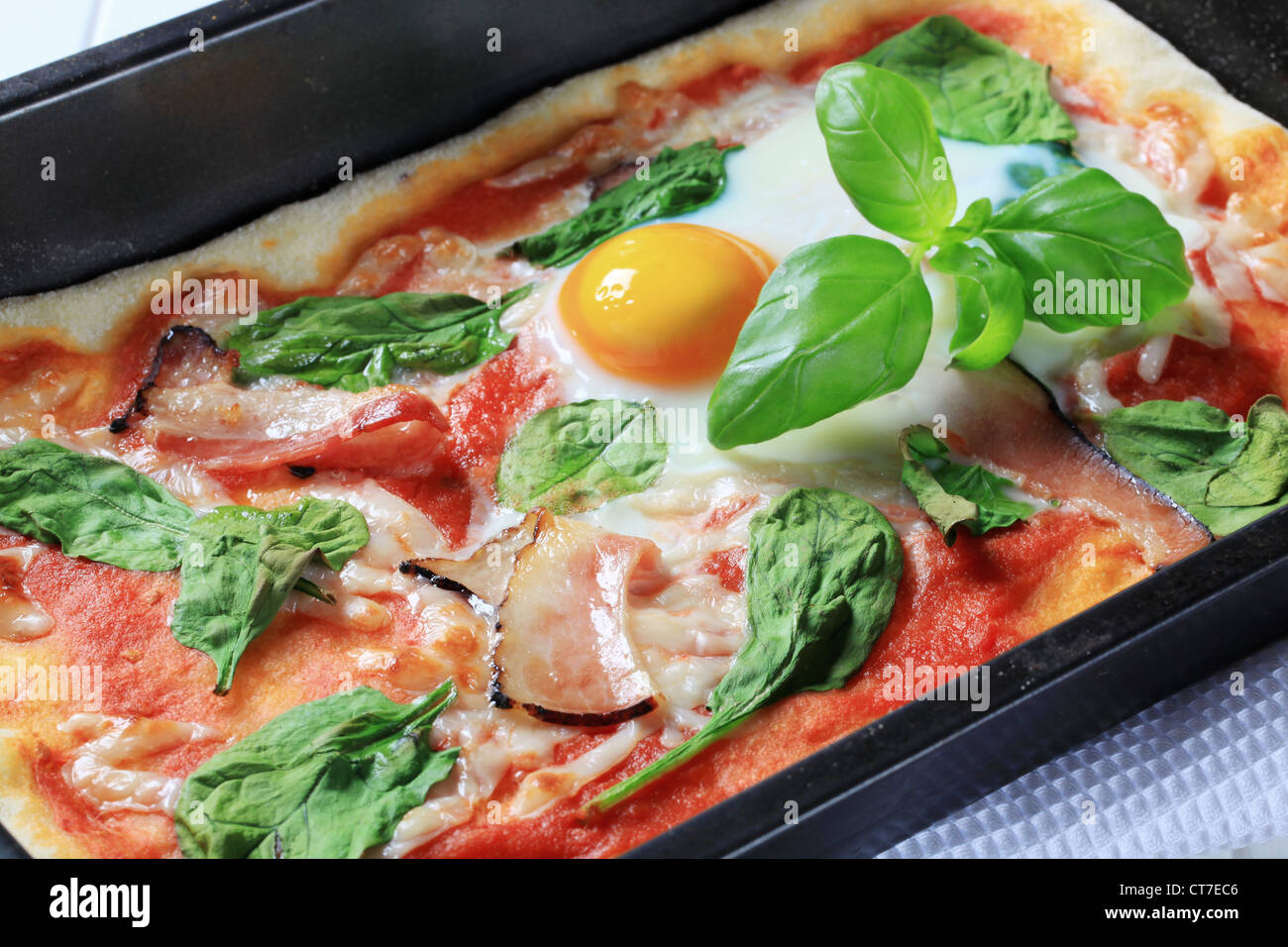 Bacon and egg pizza baked in a rectangular tray Stock Photo - Alamy