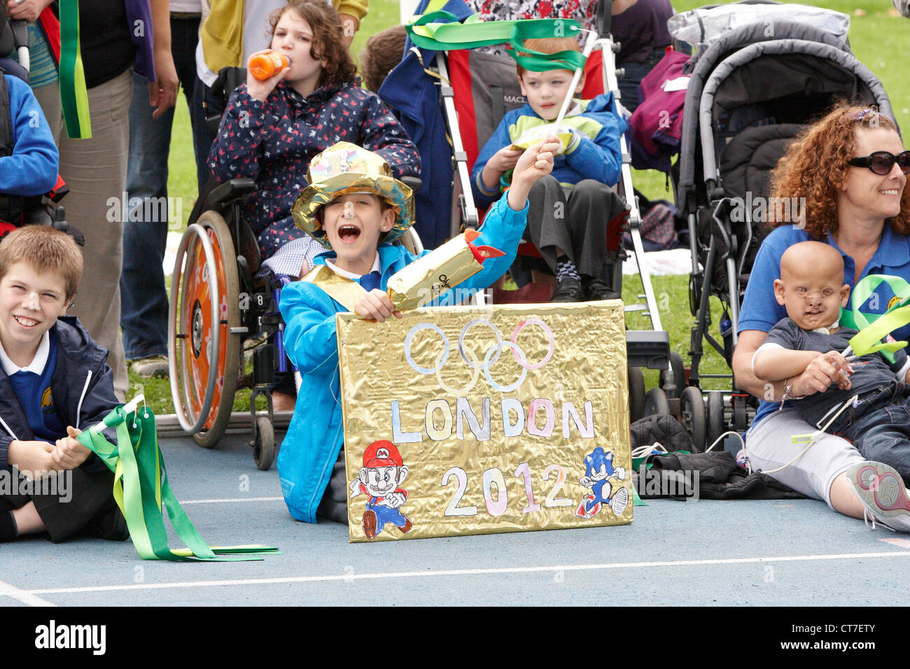 Local school children wait for the Olympic Torch in Stoke Mandeville ...