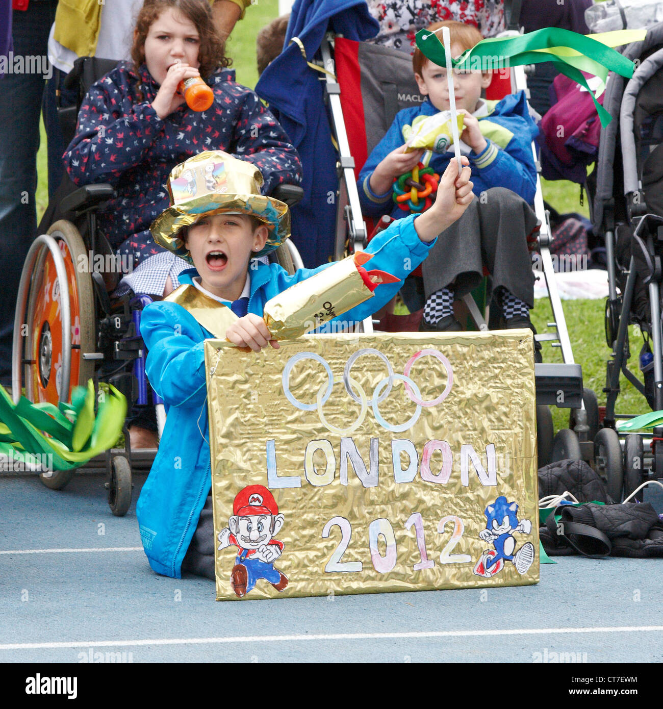 Local school children wait for the Olympic Torch in Stoke Mandeville ...