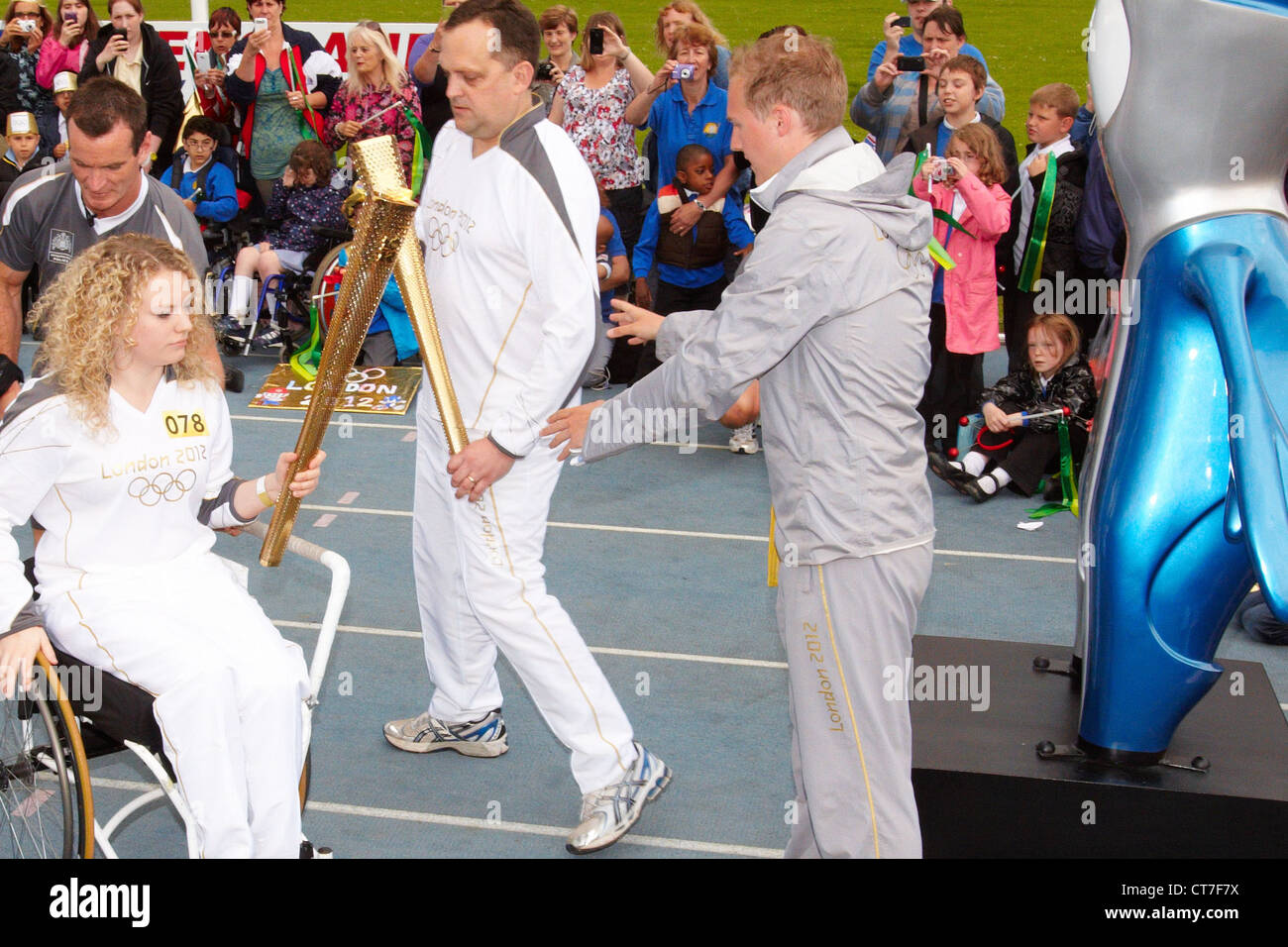 Gemma Collis (R) passes the Olympic Torch to Ian Estick (L) in Stoke ...