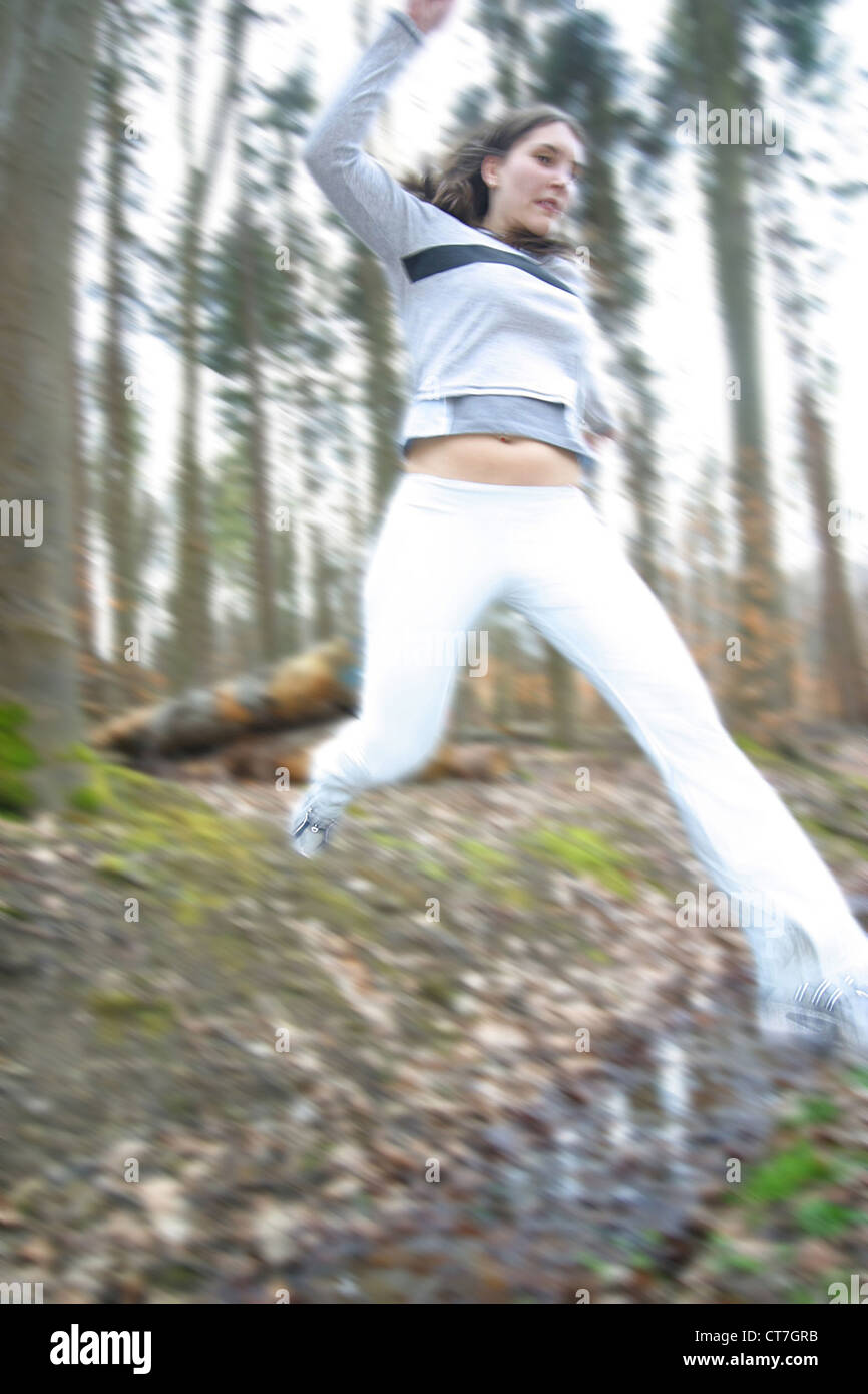 Woman jumps over a ditch during jogging Stock Photo - Alamy