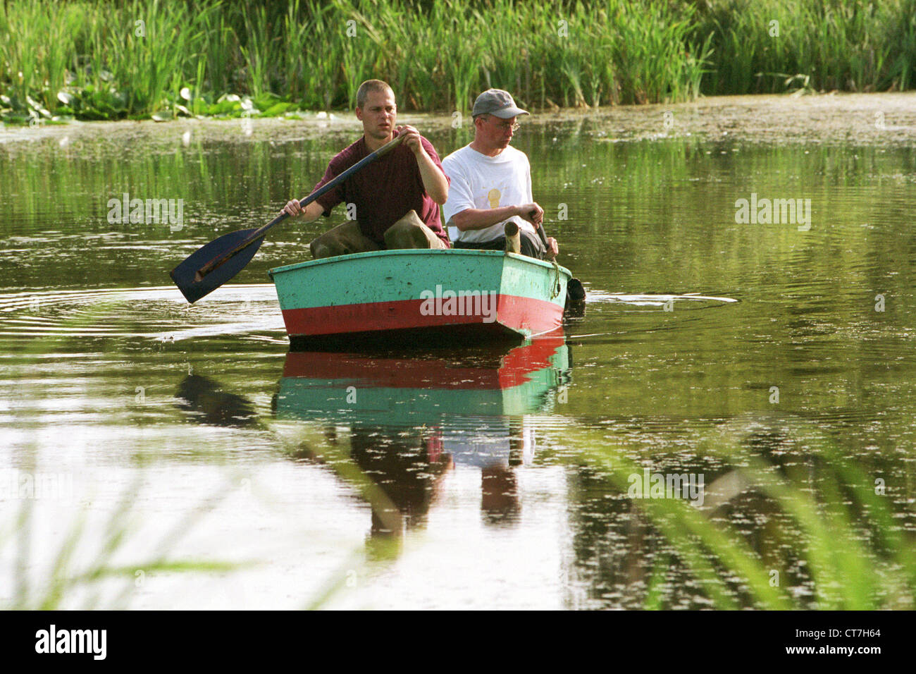 Two men in a boat on a pond Stock Photo - Alamy