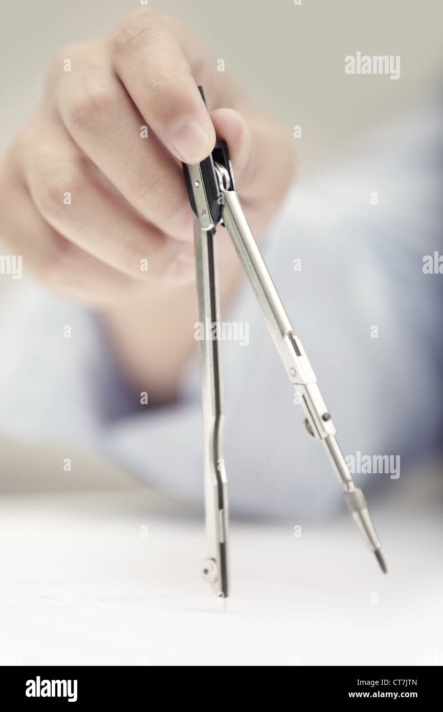 Hand of engineer working with compasses Stock Photo - Alamy
