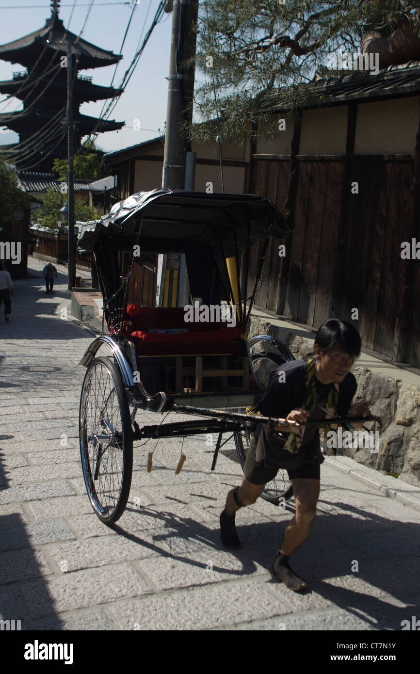 A man pulls a Rickshaw up a hill in the Japanese city of Kyoto, Japan ...