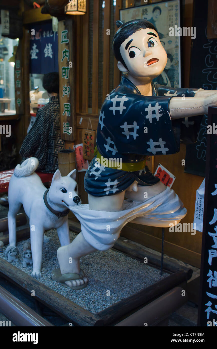 Dog and running man figurine statue outside a restaurant in Kyoto ...