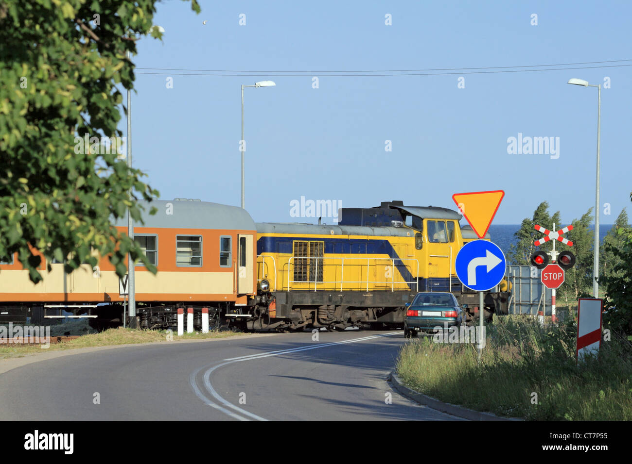 Passenger train passing the railroad crossing with the road Stock Photo ...