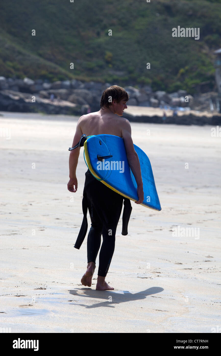 Surfer Carrying Surfboard at Newquay Stock Photo - Alamy