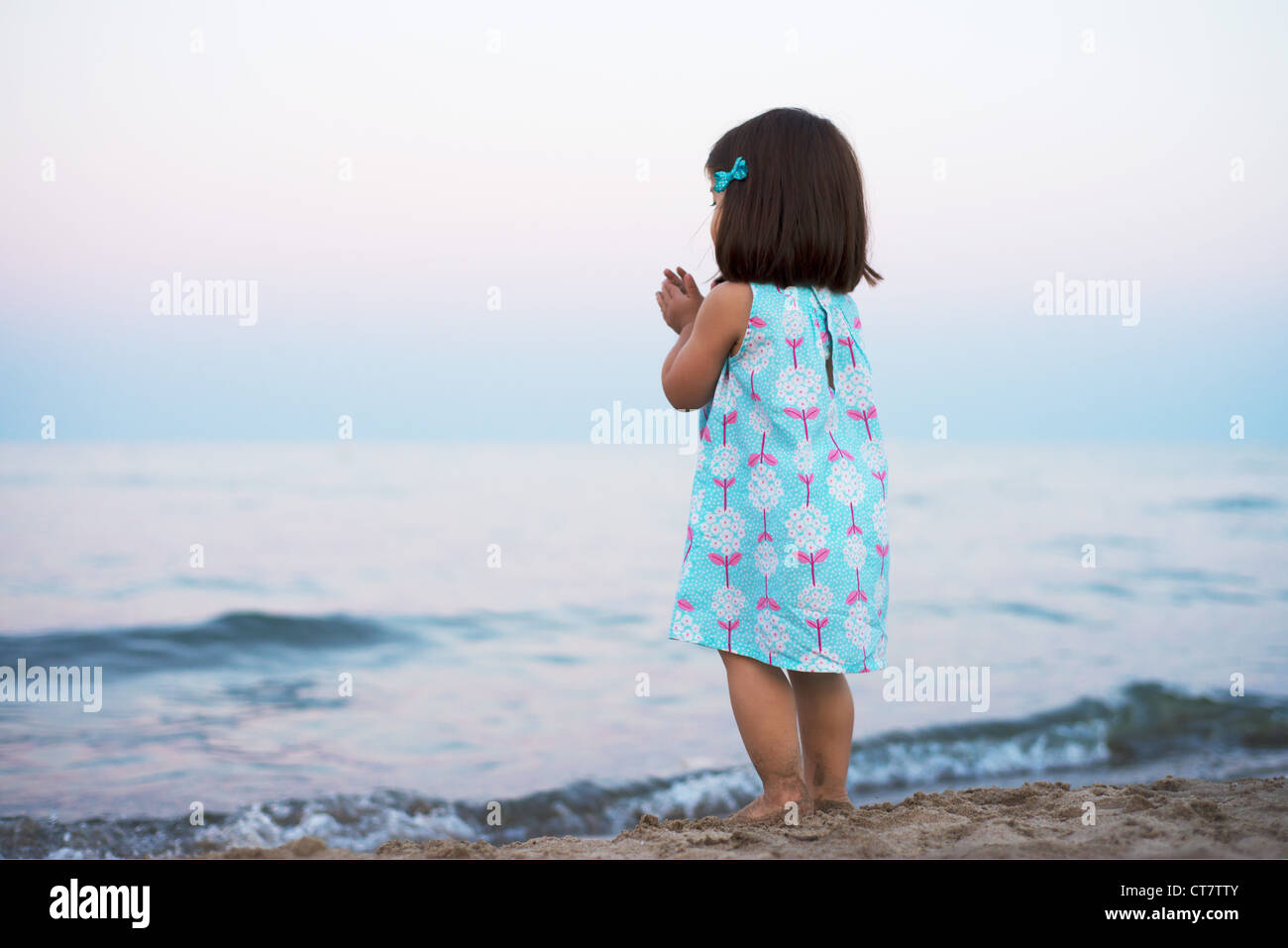 Girl looking out across open water in the late evening Stock Photo - Alamy