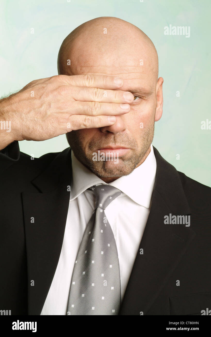 Man with hand over eyes Stock Photo - Alamy