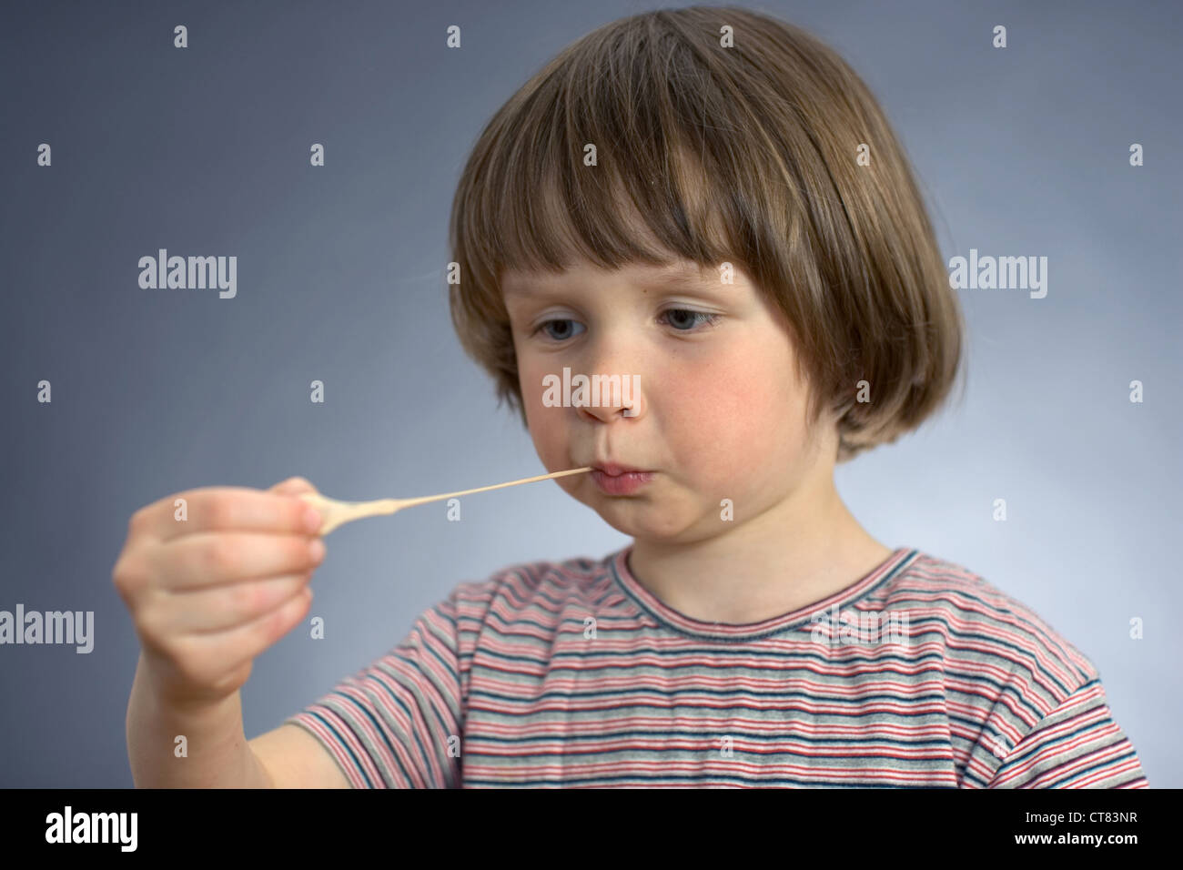 A child pulls a piece of gum out of his mouth Stock Photo - Alamy