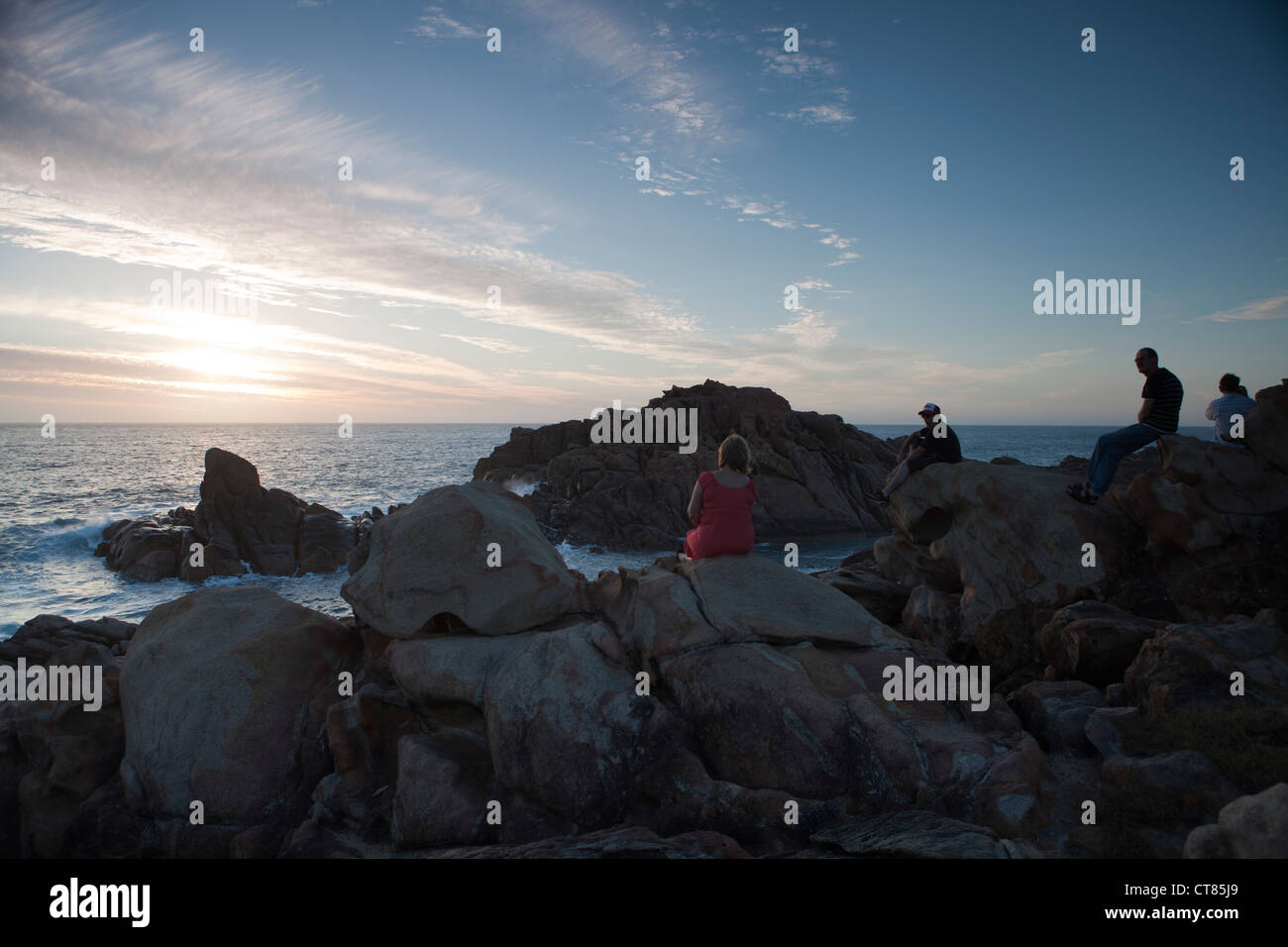 A group of people gathered to watch the sunset at Canal Rocks near ...