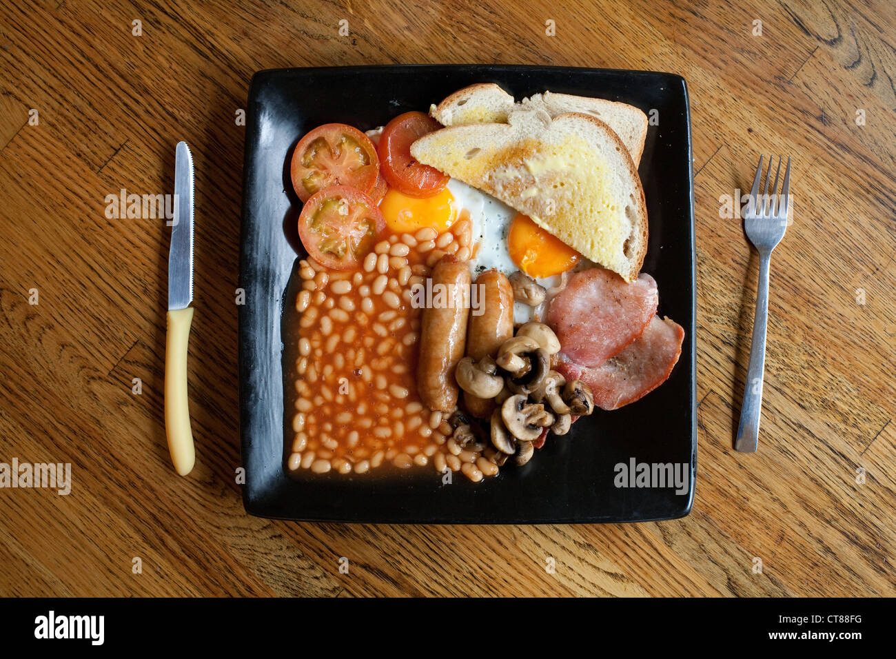 Full English breakfast / Fry up on a square black plate Stock Photo - Alamy