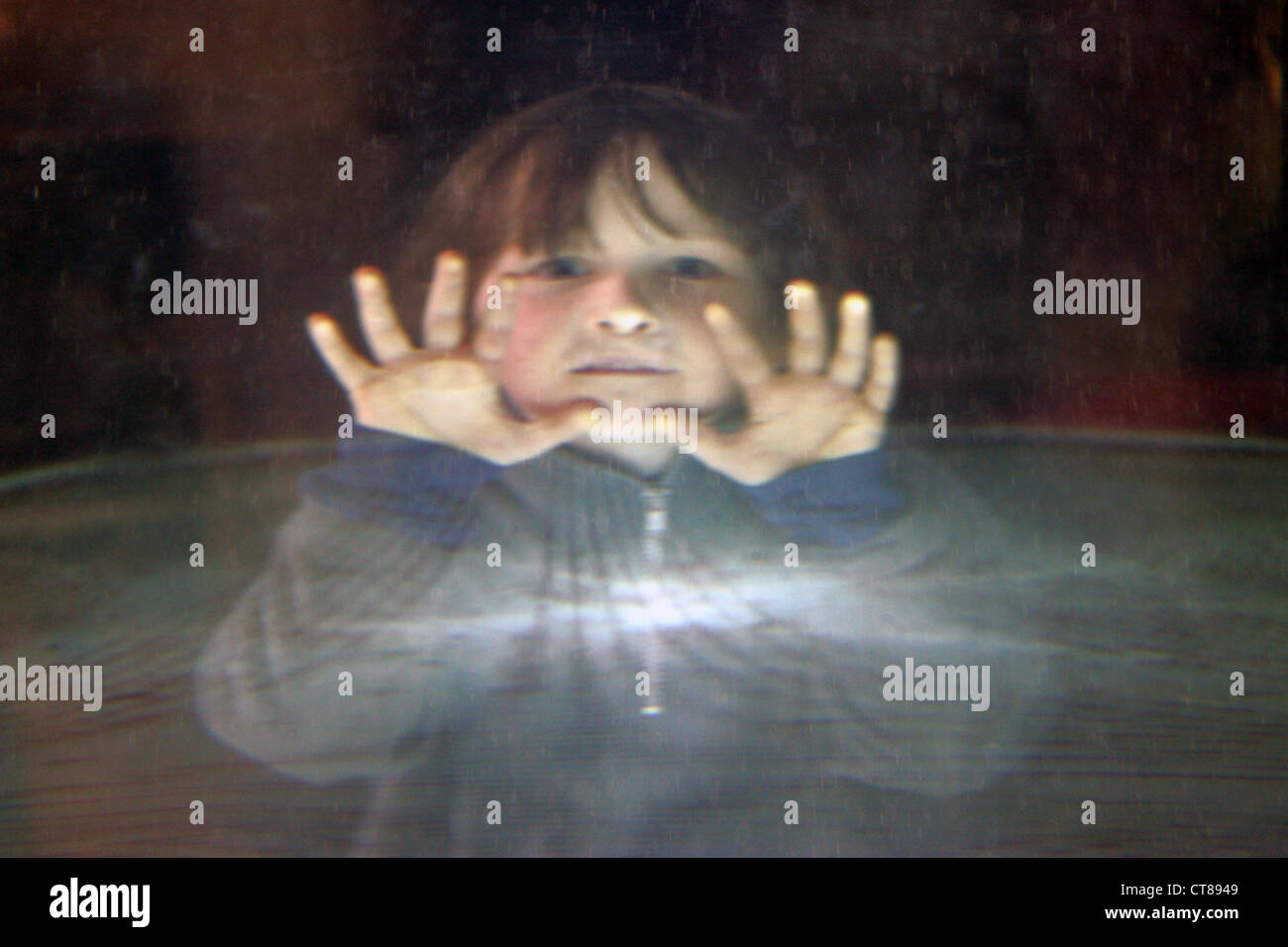 A child looking through a pane of glass Stock Photo - Alamy