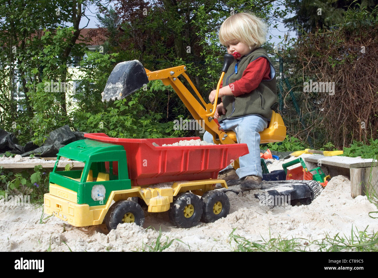 A toddler playing in sandbox Stock Photo - Alamy