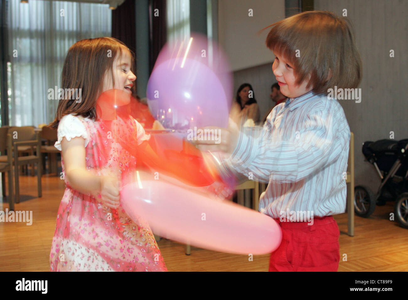 Two children playing with balloons Stock Photo - Alamy