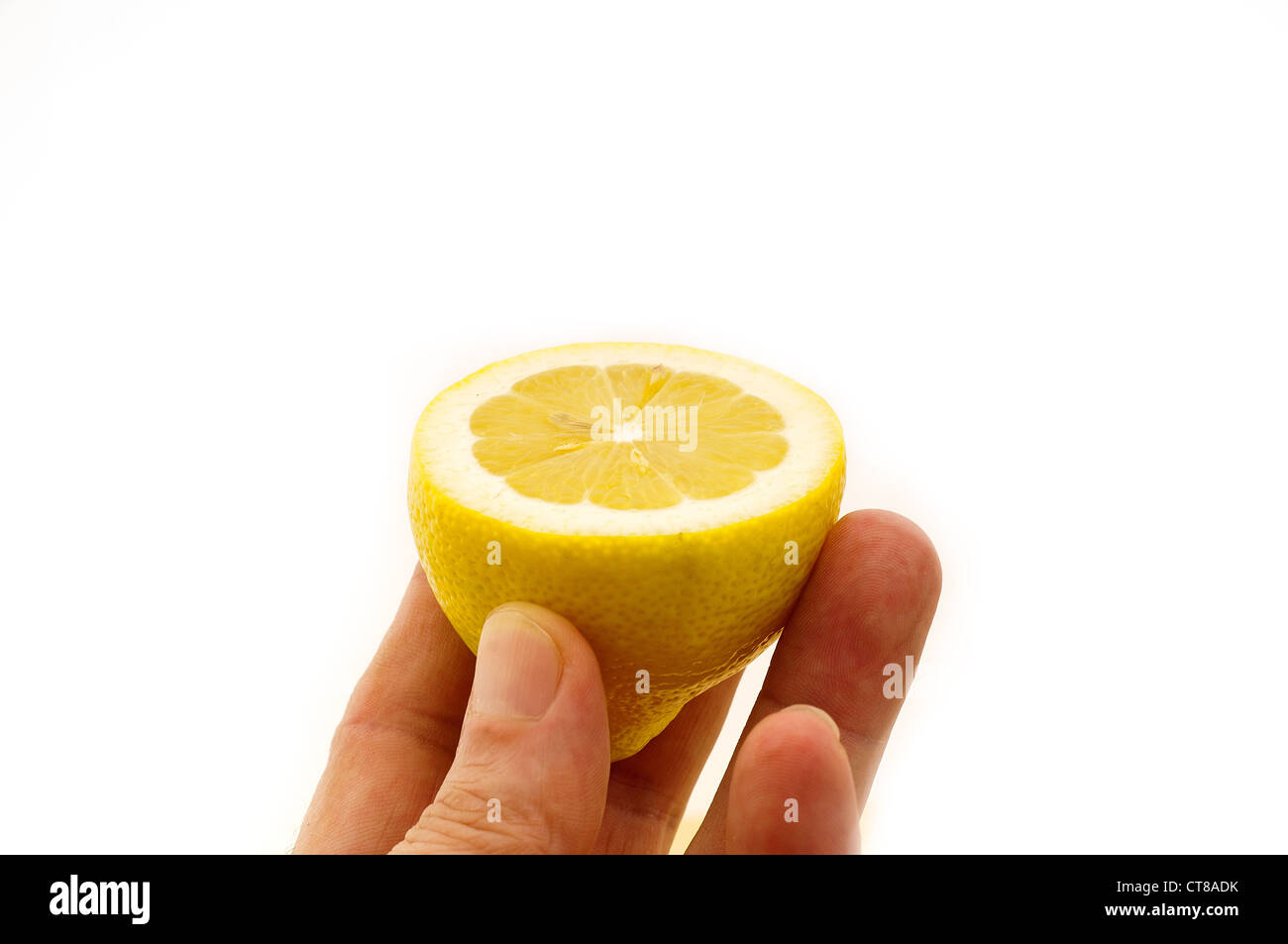 fresh ripe lemon cutted in half hold in hand closedup Stock Photo - Alamy