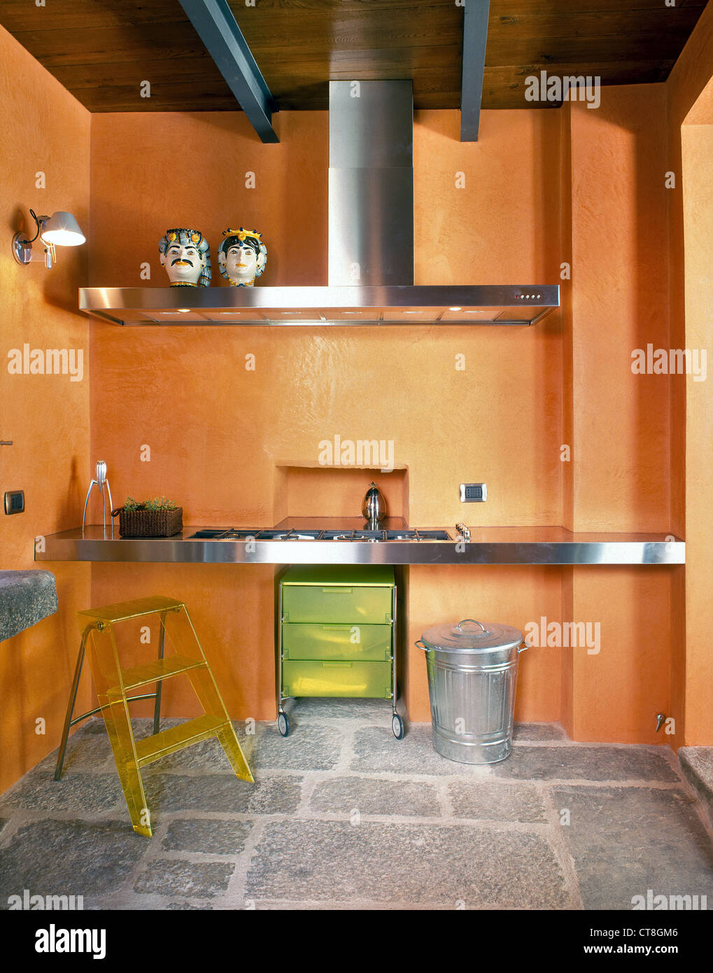 hi-tech kitchen with orange wall, stone sink and stone floor Stock ...