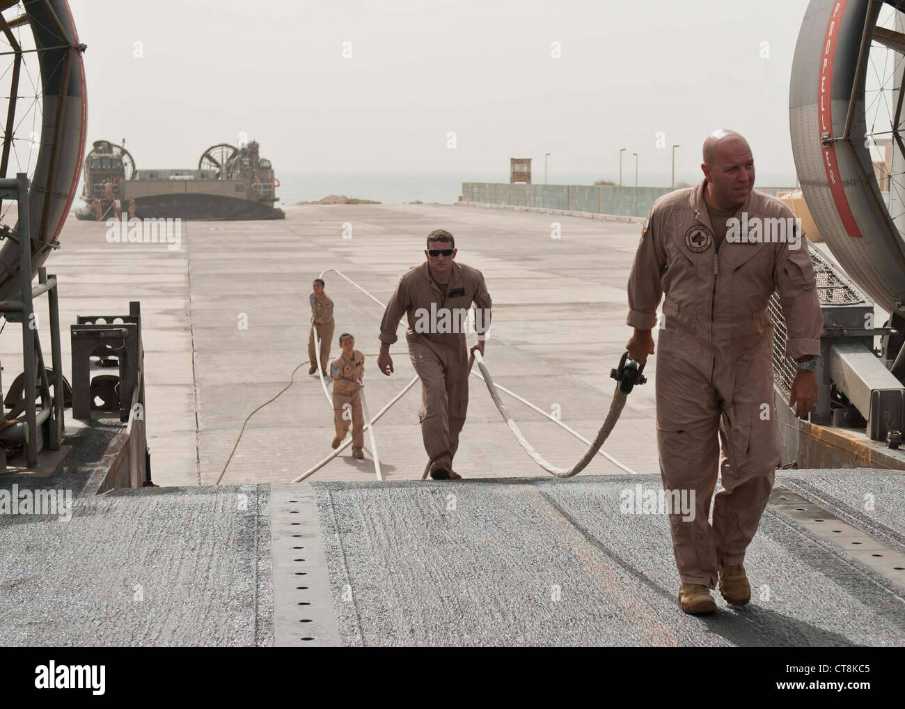 Sailors assigned to Assault Craft Unit (ACU) 4 retrieve a tow line ...