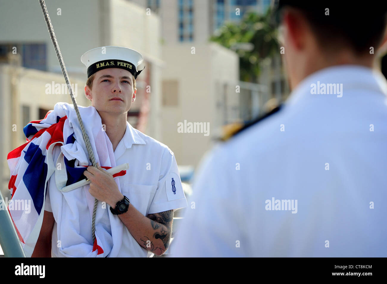 Able Seaman Benjamin Mafrici prepares to raise the colors aboard the ...