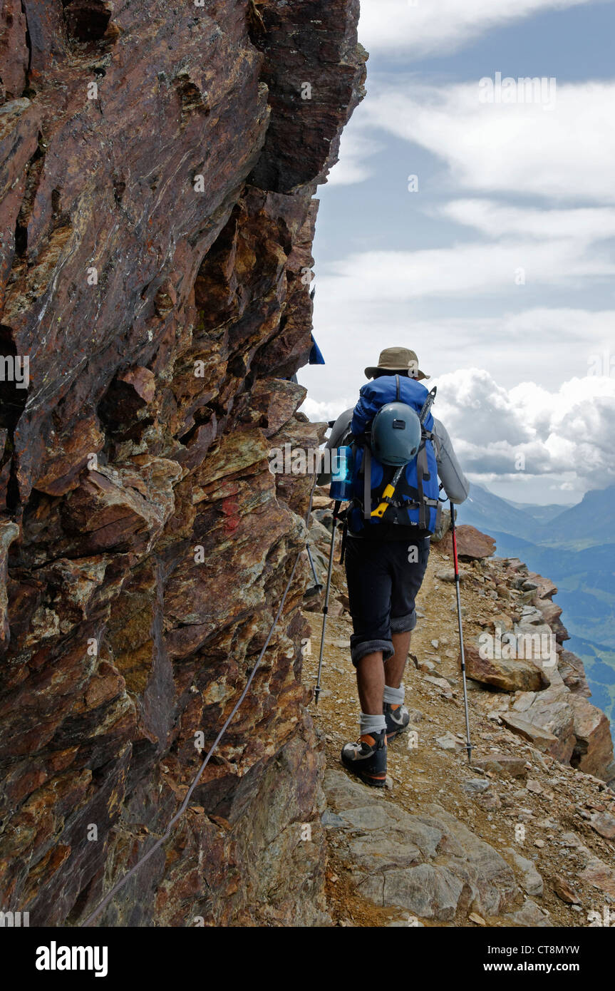 An alpinist walking on a mountain path Stock Photo - Alamy