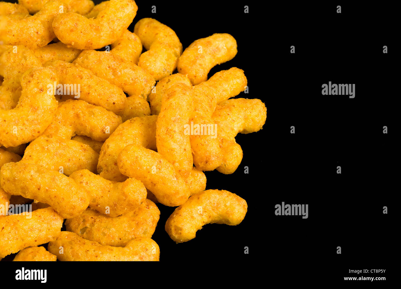A heap of cheesy peanut snacks on black Stock Photo - Alamy