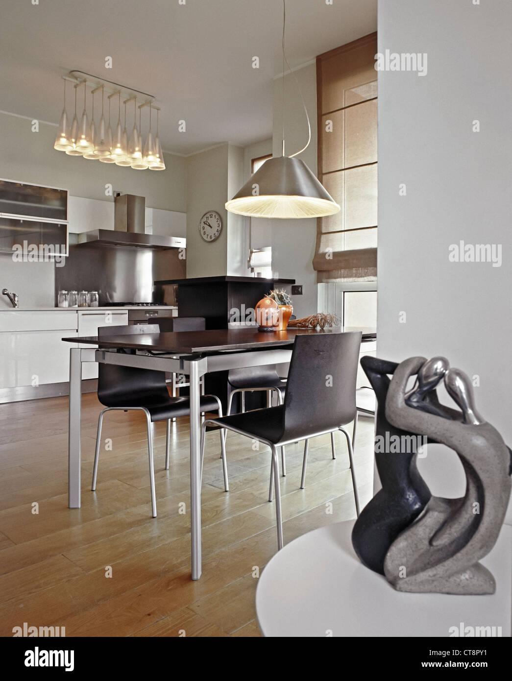 modern kitchen with wood floor and table in the center Stock Photo - Alamy