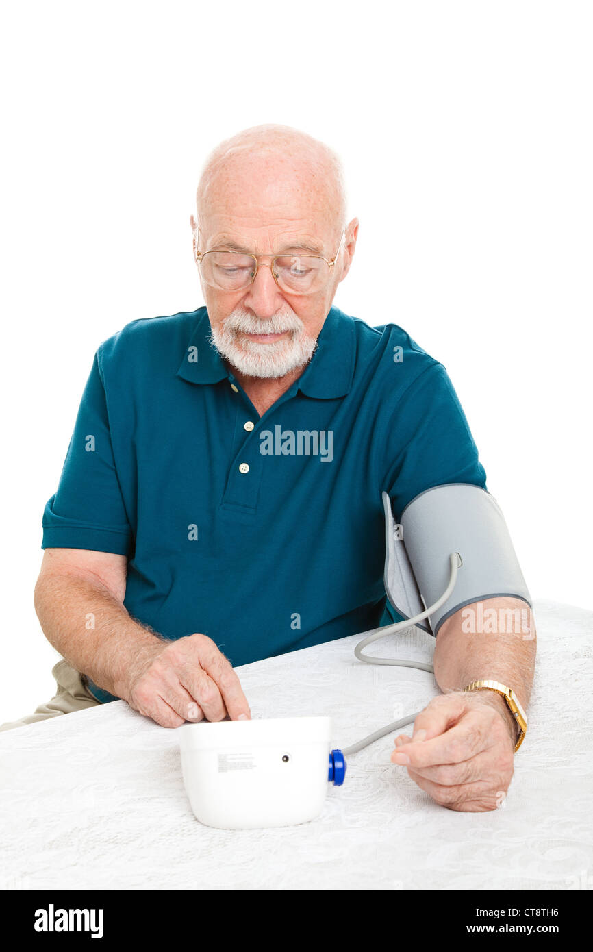 Senior man using a home blood pressure machine to check his vital ...