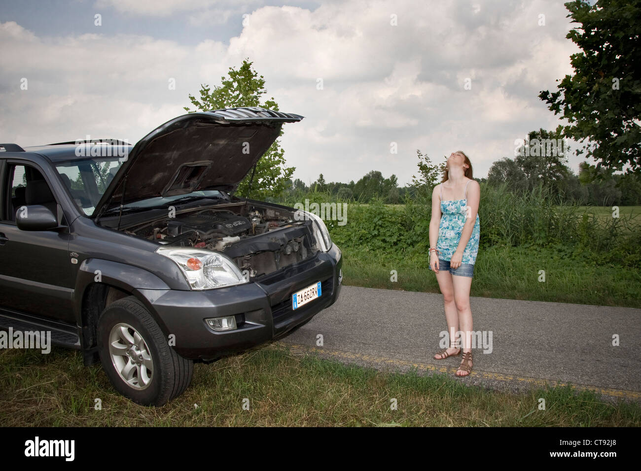Young woman with a broken down car Stock Photo - Alamy