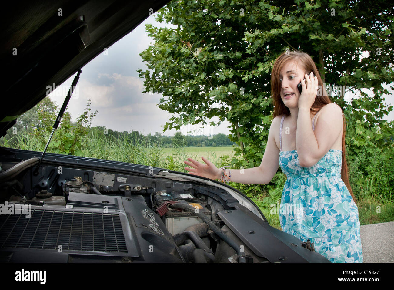 Young woman with a broken down car Stock Photo - Alamy