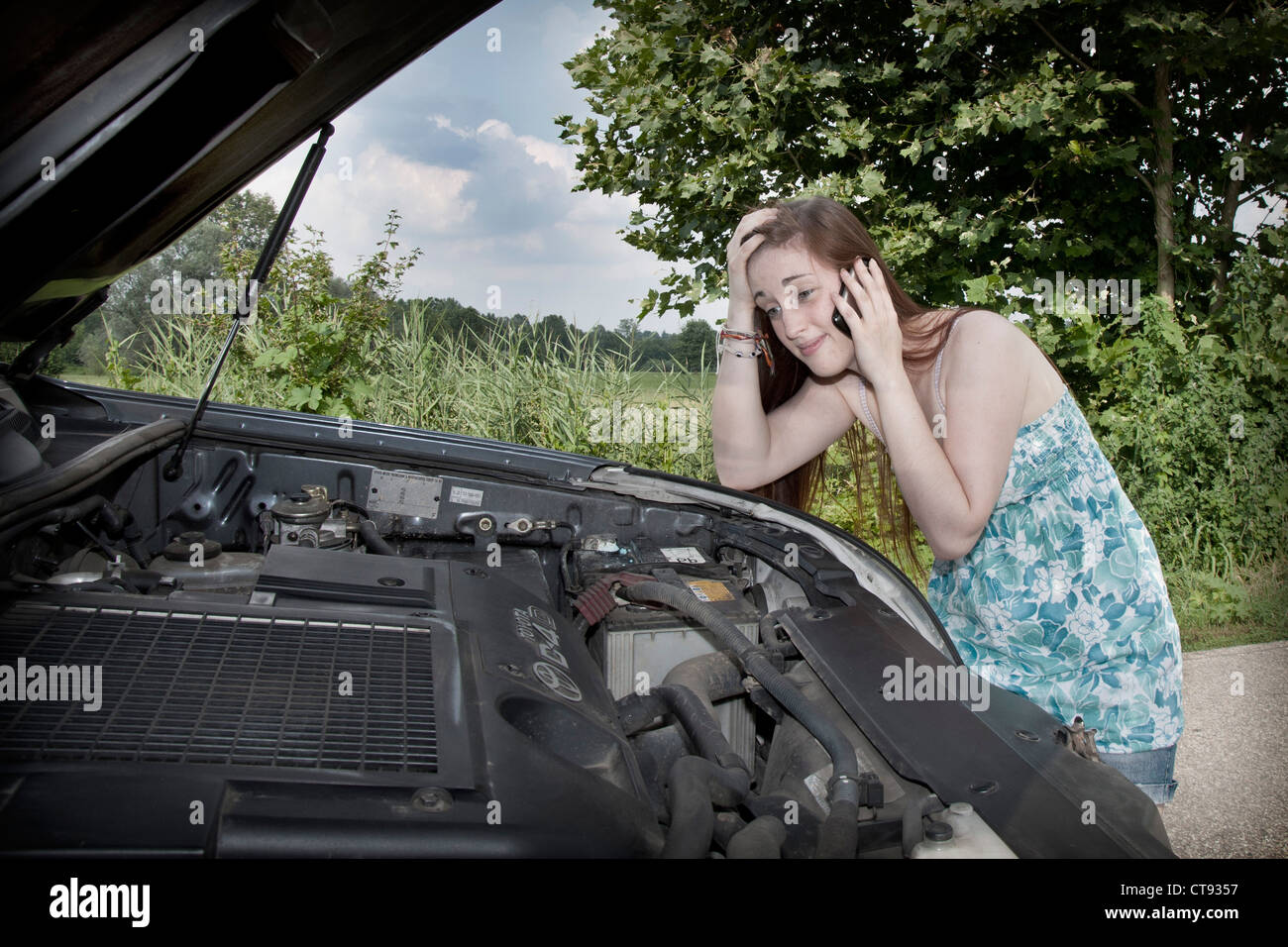 Young woman with a broken down car Stock Photo - Alamy