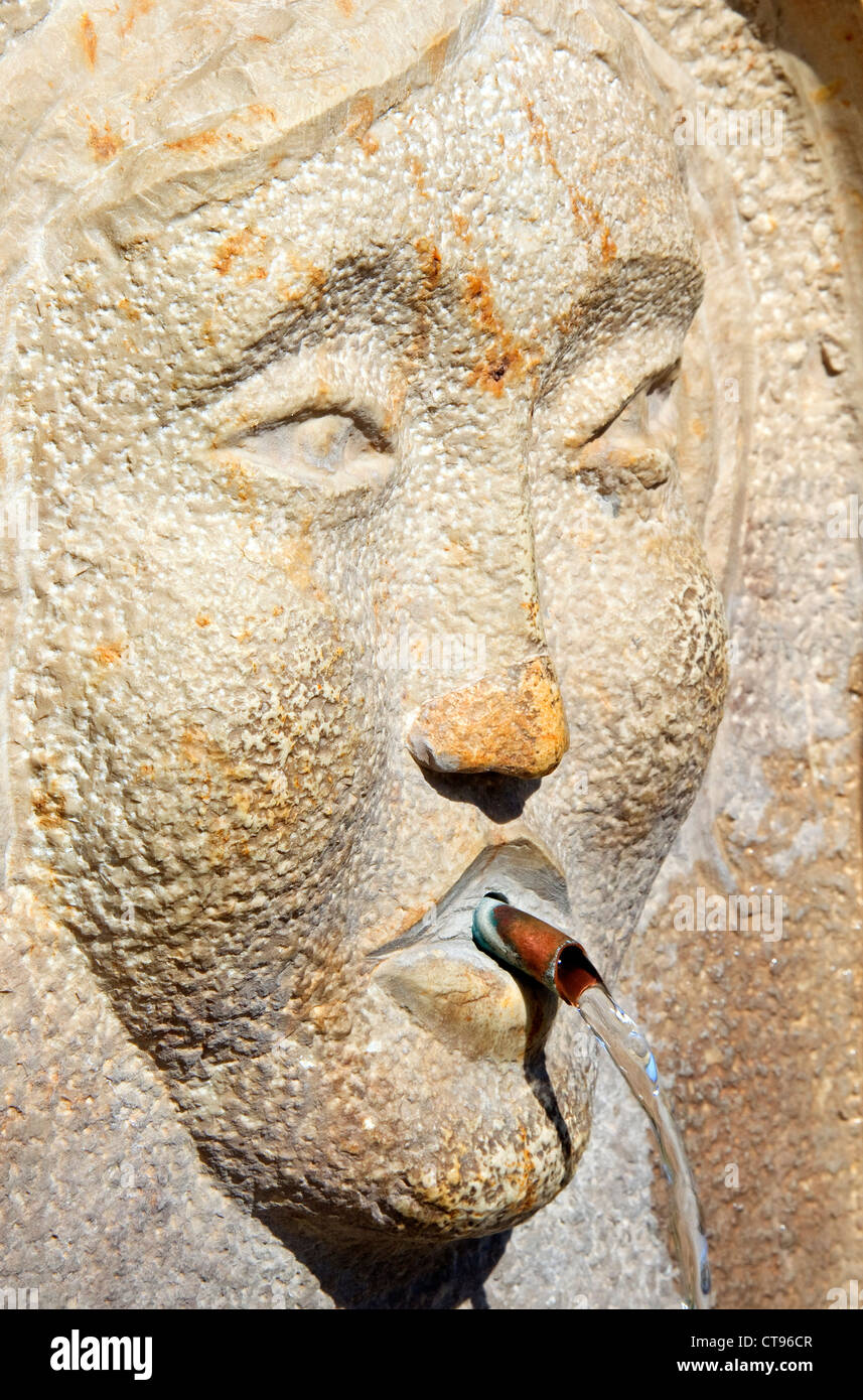 Stone face with a water spout for public drinking, France Stock Photo ...