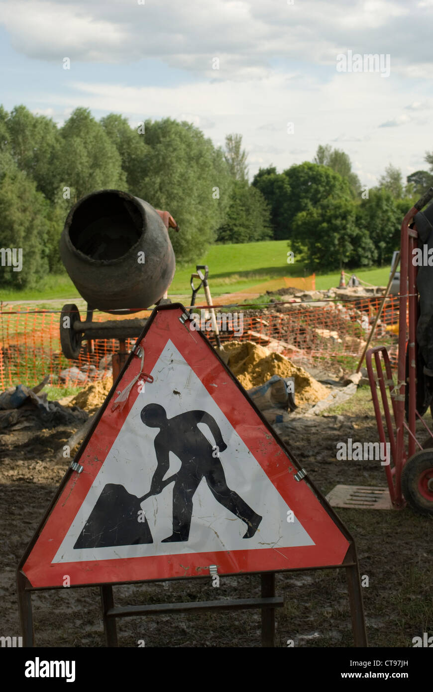 Men at work road sign and cement mixer on building site Stock Photo - Alamy
