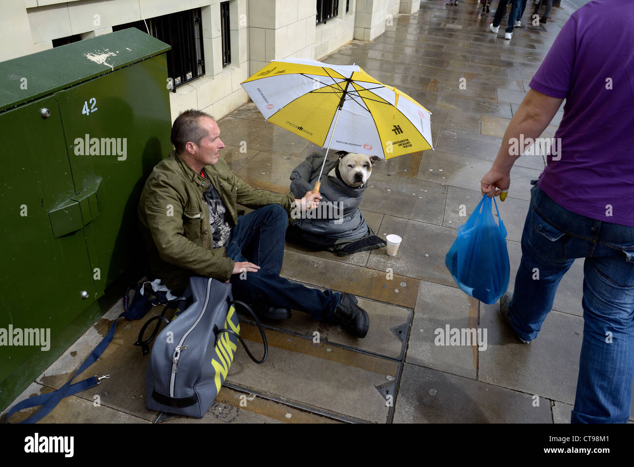 man shields dog from rain in london Stock Photo - Alamy