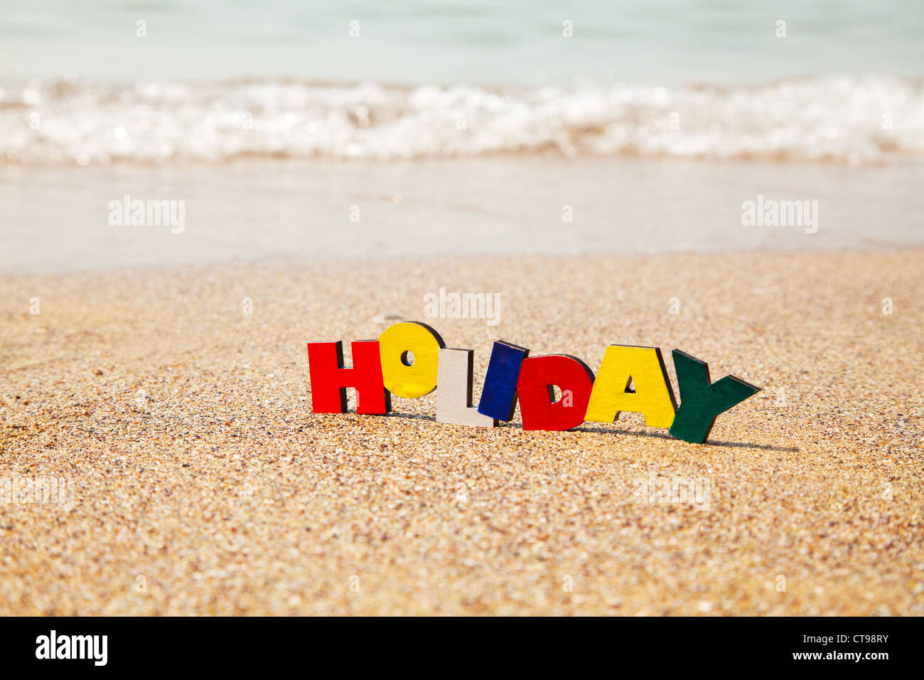 Wooden colorful word 'Holiday' on the sand Stock Photo - Alamy