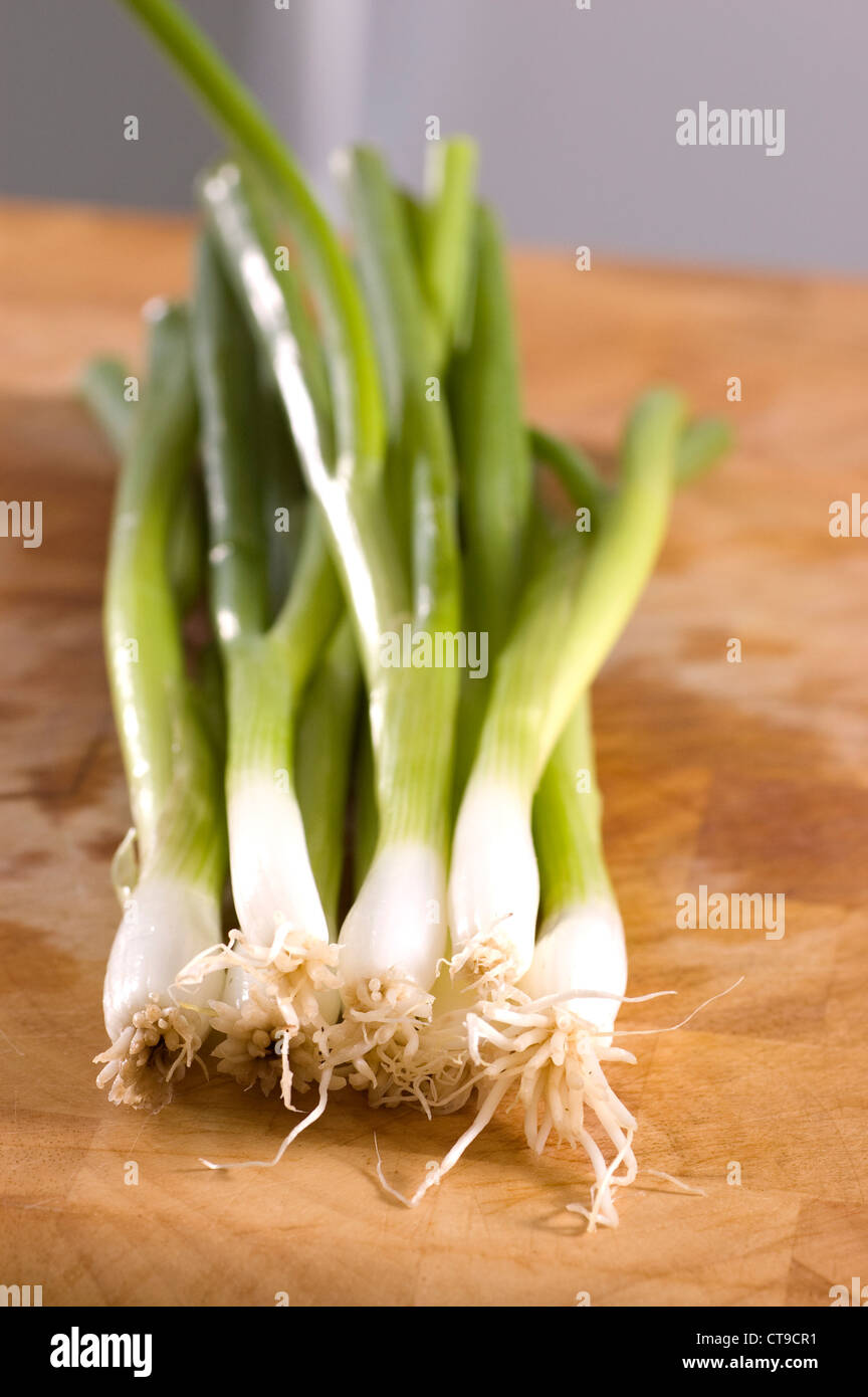 Spring onions on a wooden board Stock Photo - Alamy