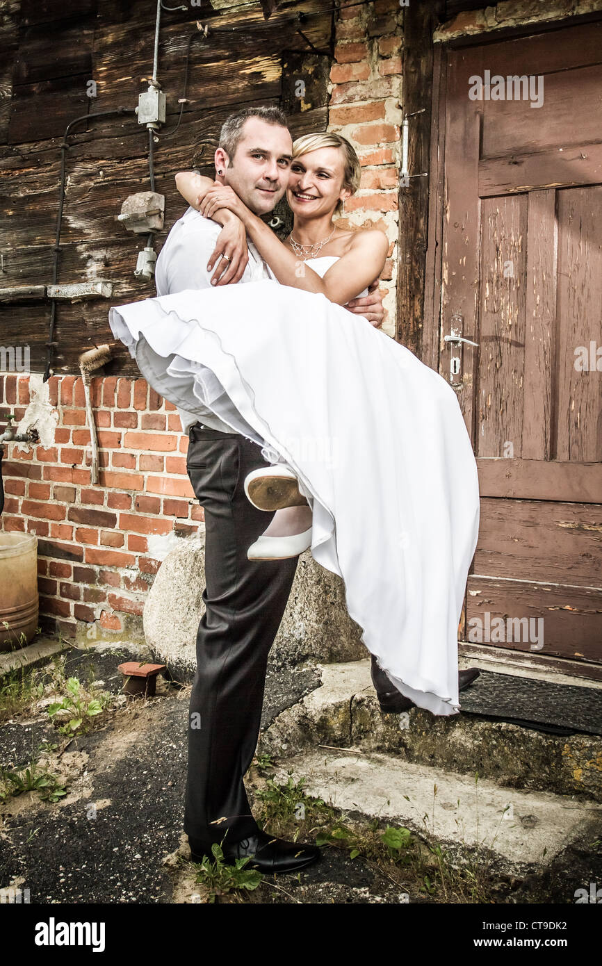 The groom brings the bride to the house Stock Photo - Alamy