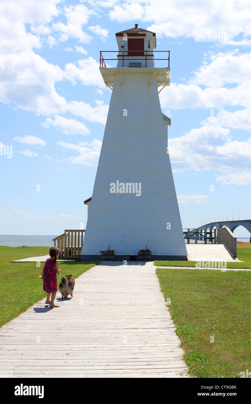 Little girl walking her Sheltie dog by a lighthouse in Prince Edward ...