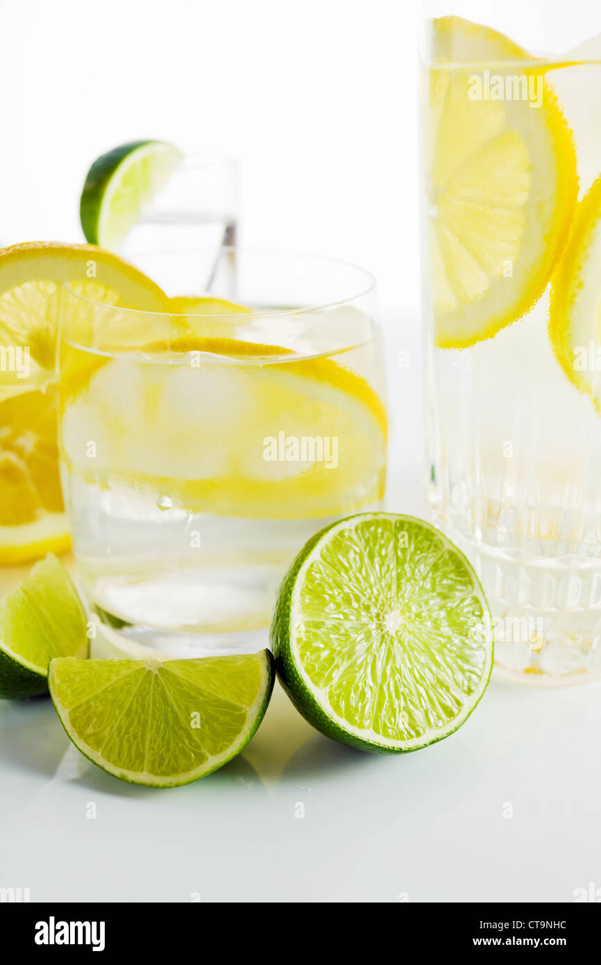 drinks with lemon and lime, shot on reflective white background Stock ...