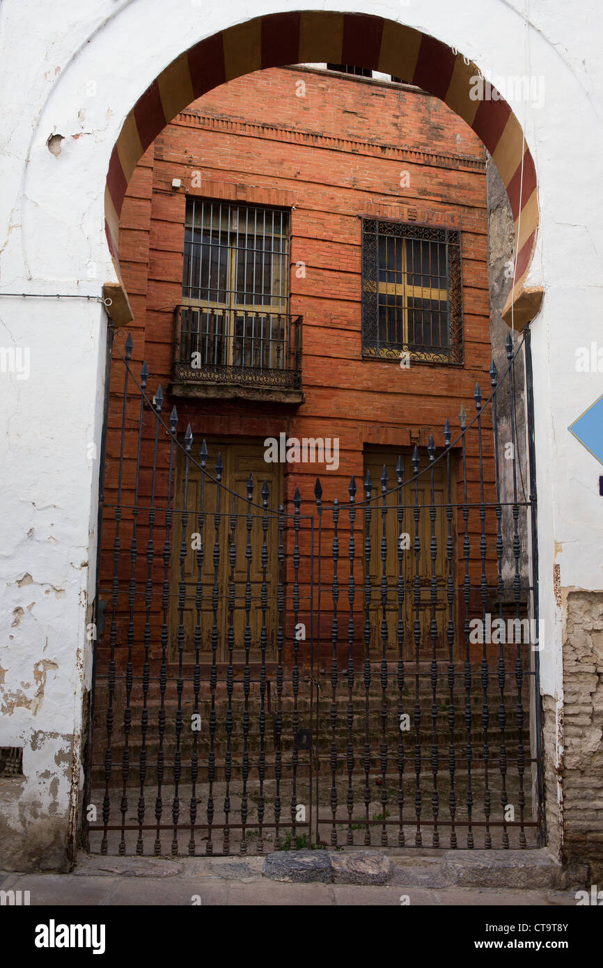 Keyhole shape closed gate entrance to an old brick house in Cordoba Old ...
