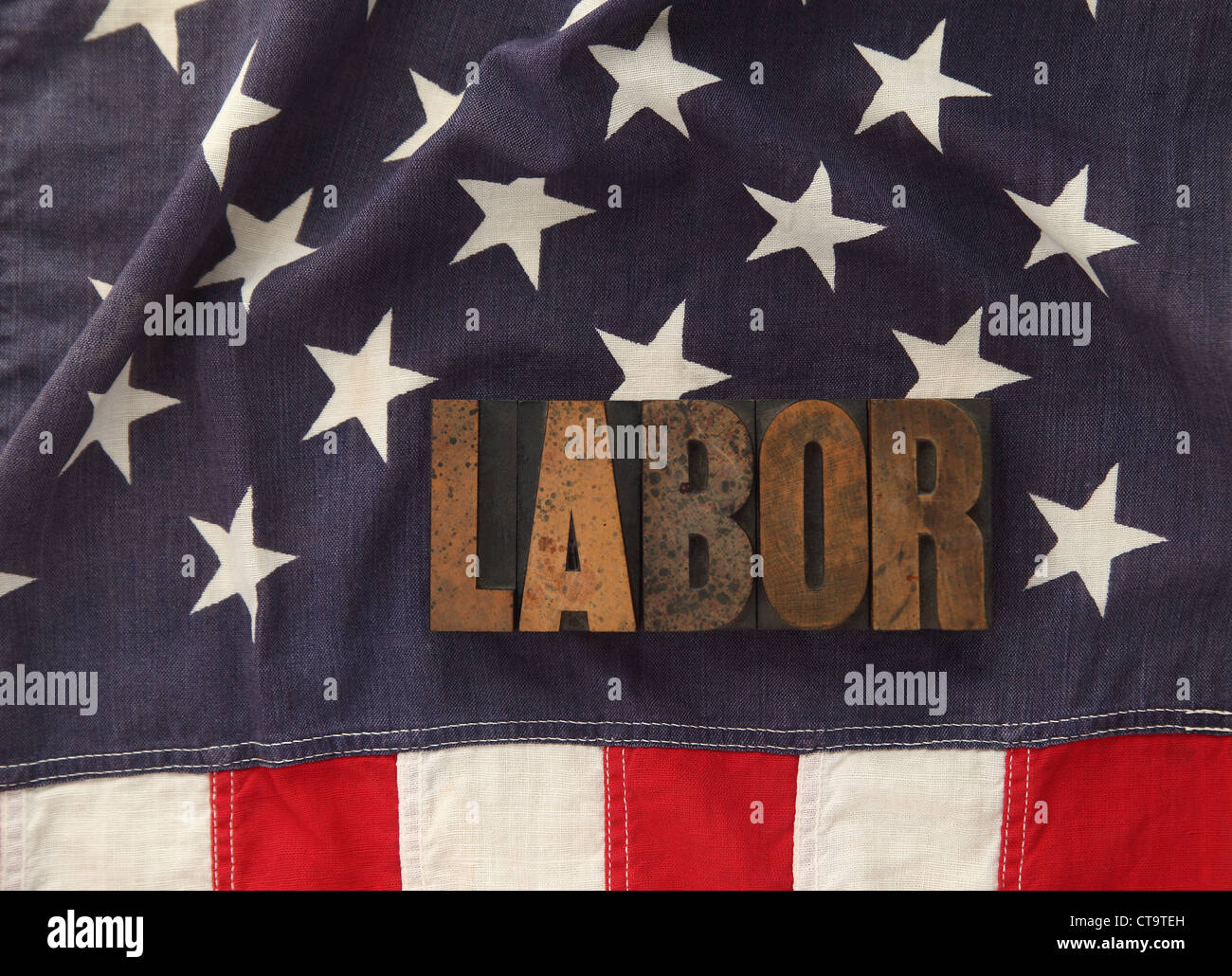the word labor in old letterpress wood type on an old flag Stock Photo ...