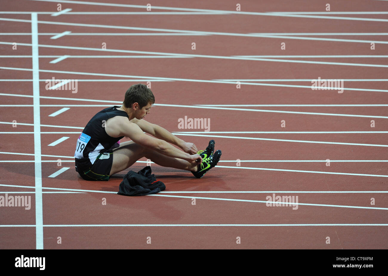 An Athletes sits on a running track Stock Photo - Alamy