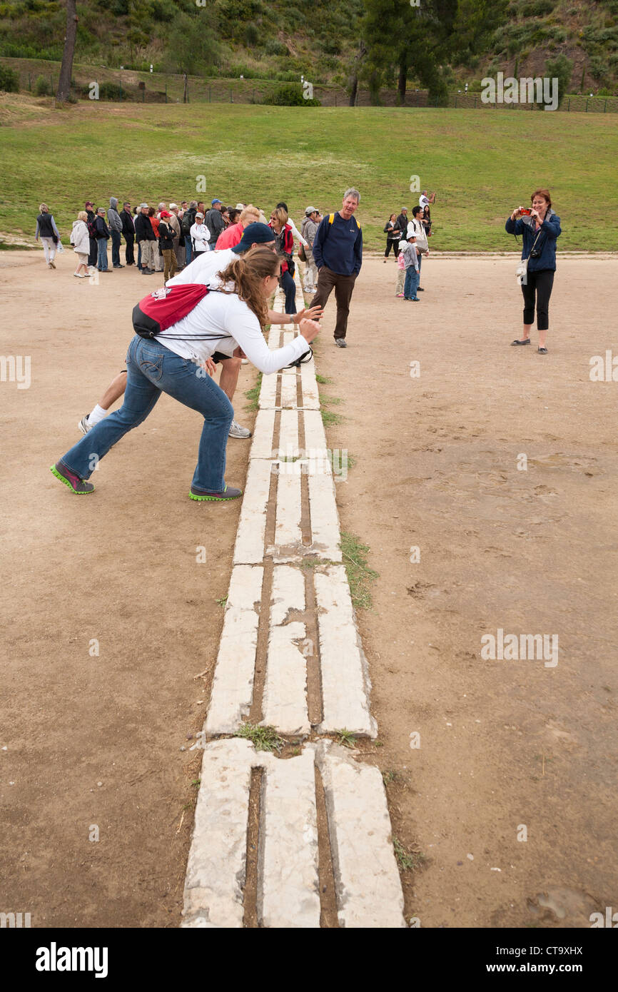 Tourists at the starting line of the original Olympic Stadium, Olympia ...
