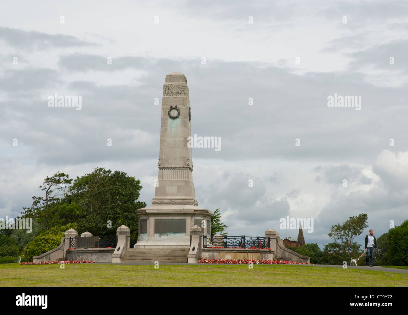 Man and dog walking past the cenotaph in Barrow Park, Barrow-in-Furness ...