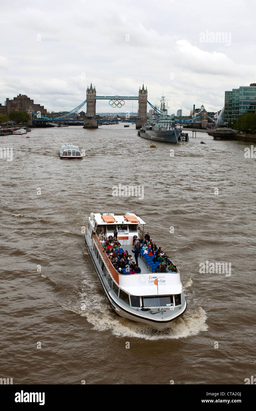 A tourist boat cruises on the Thames River near the London Bridge ...