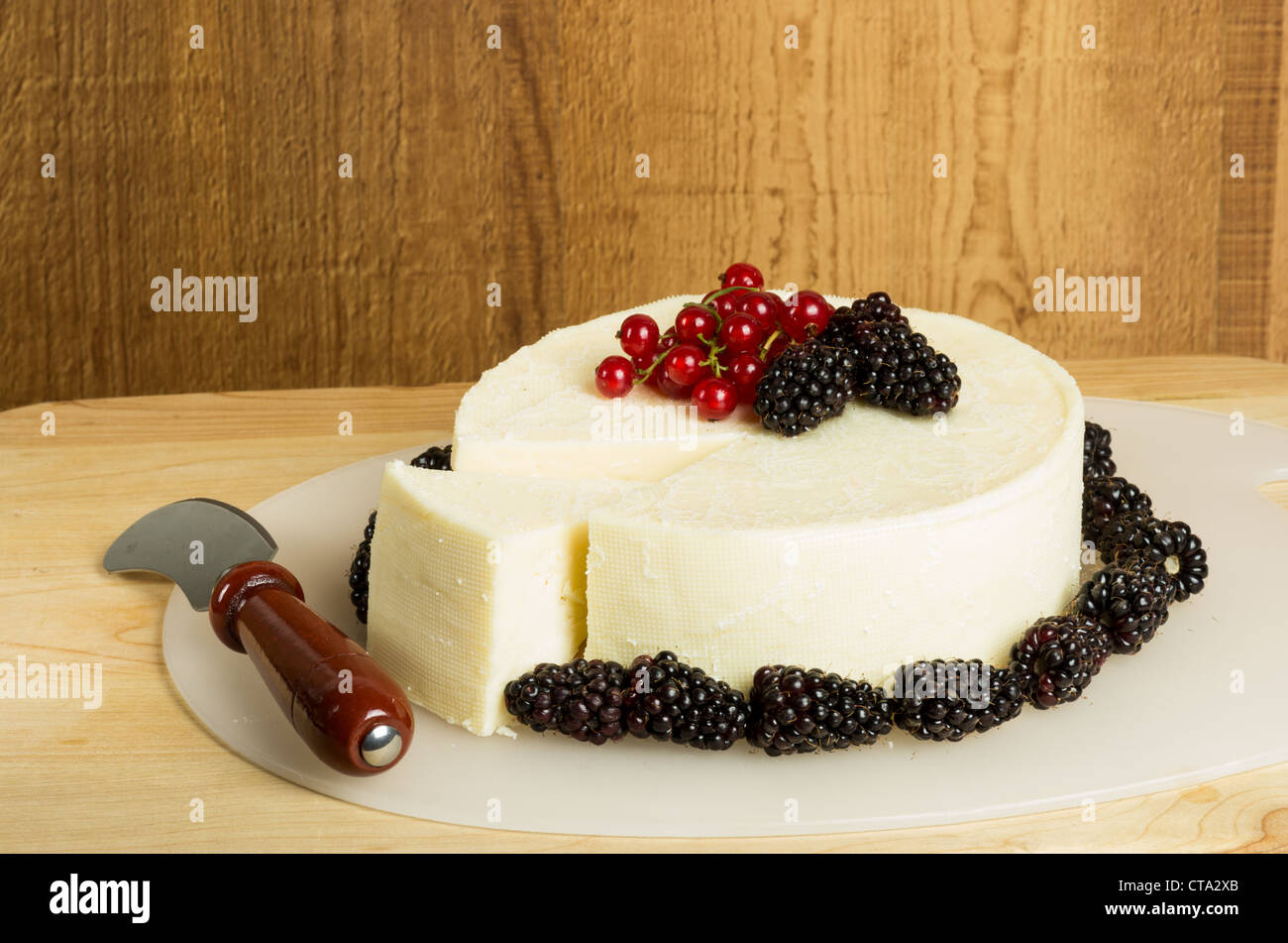 A round of cheddar cheese with knife Stock Photo - Alamy