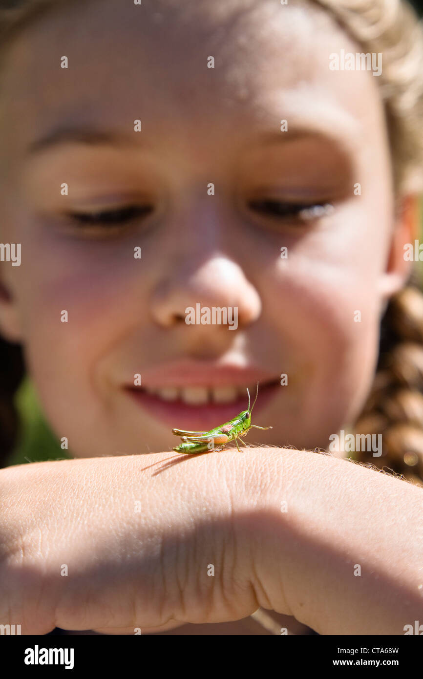 Girl (8 years) with grasshopper on hand, Bavaria, Germany Stock Photo ...
